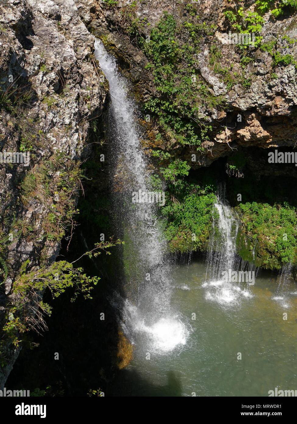 Curtains of dripping water from a small waterfall viewed from the top ...