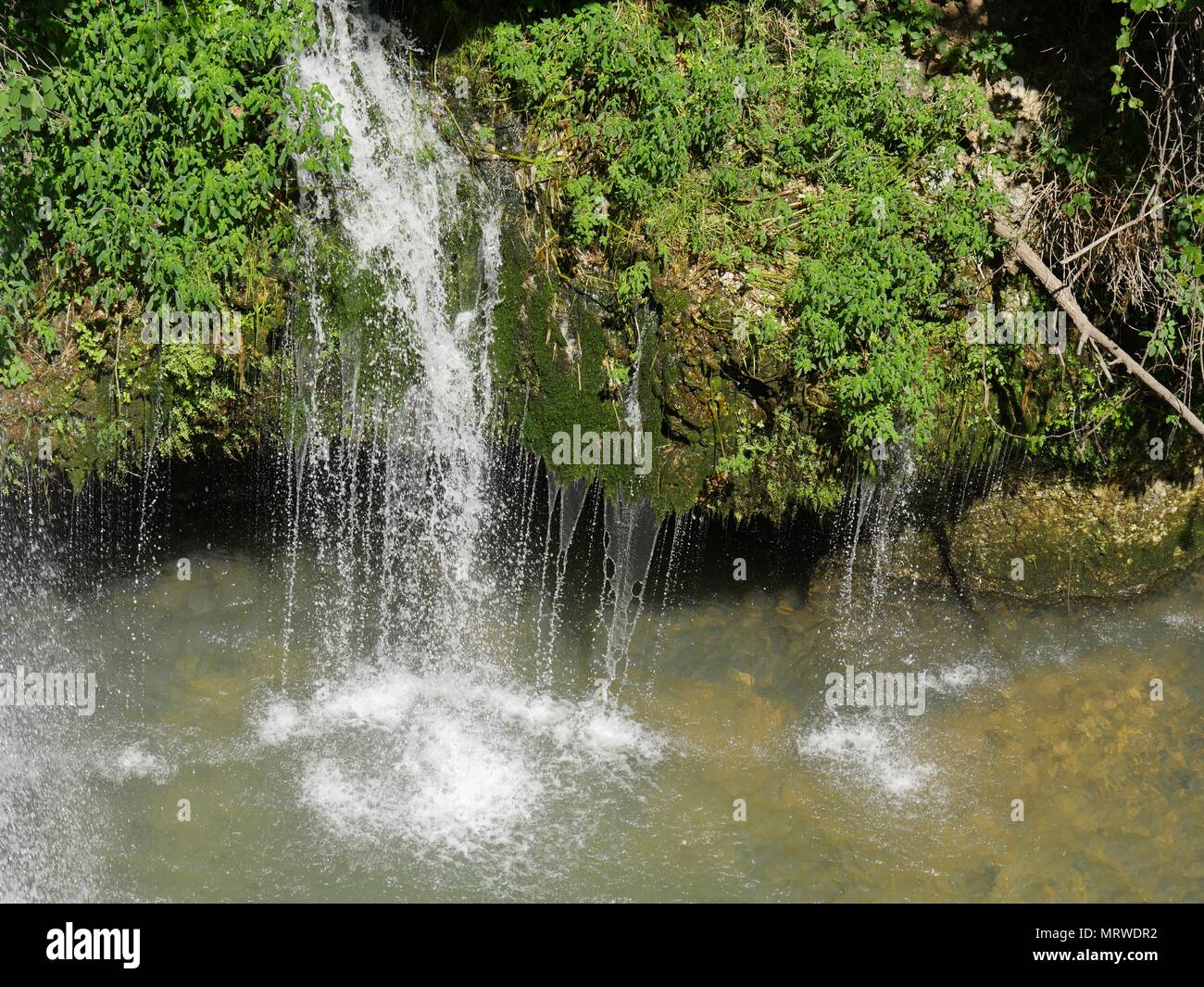 Curtains of dripping water from a small waterfall viewed from the top ...