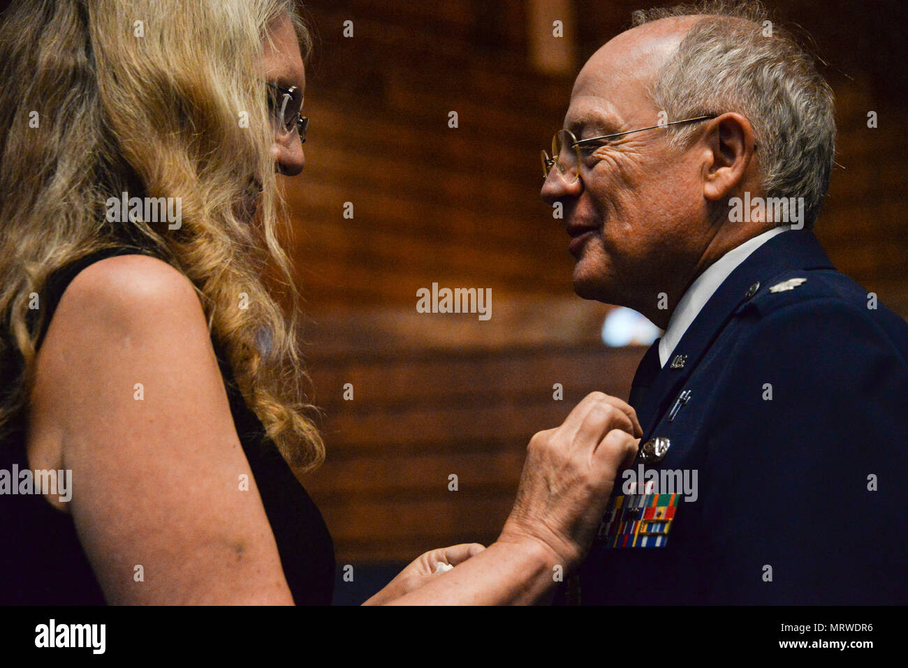 Susan Glass pins on the retirement pin to her husband Lt. Colonel James ...