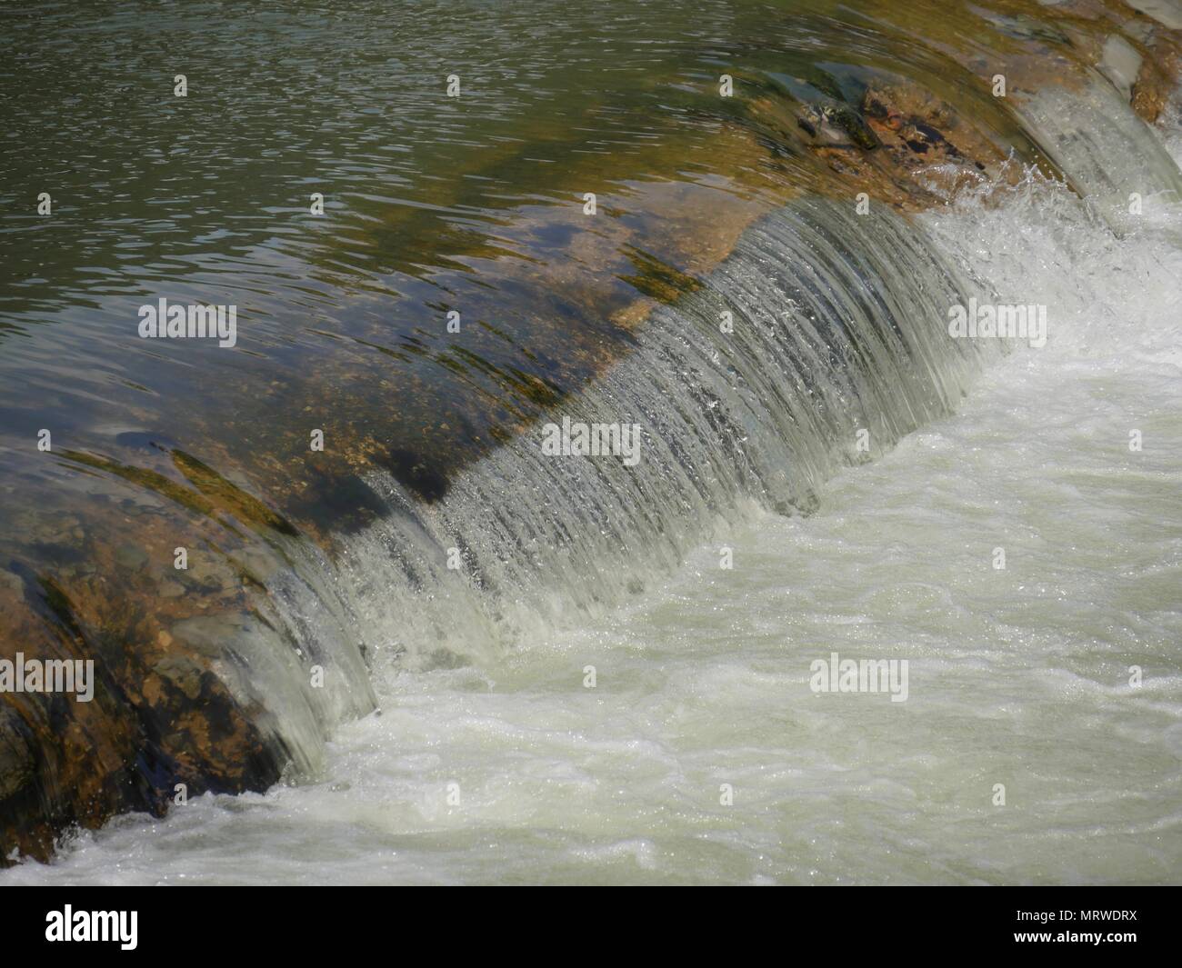Water cascades down a small drop in the river Stock Photo - Alamy