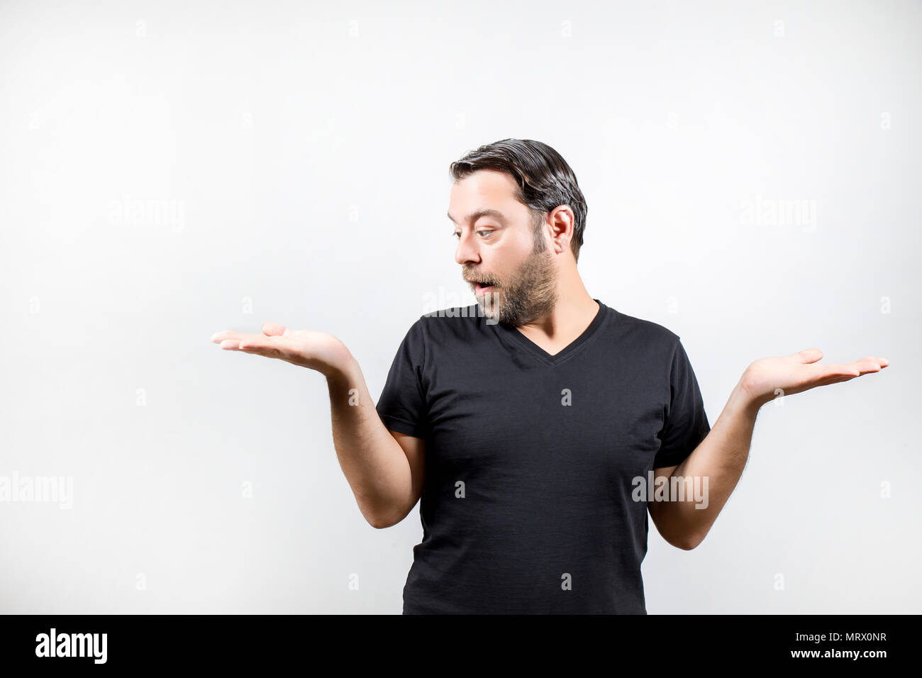 Adult man is comparing things on his hand and surprised Stock Photo - Alamy