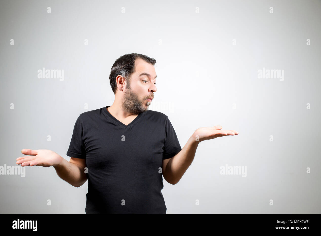 Adult man is comparing things on his hand and surprised Stock Photo - Alamy