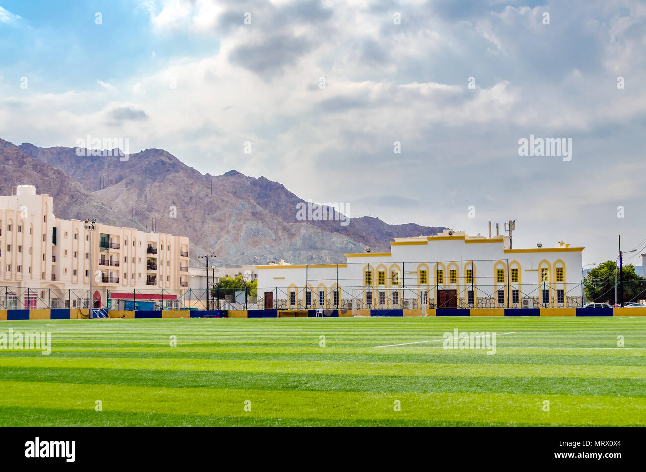Small football field in Muscat, Oman with buildings and mountains in ...