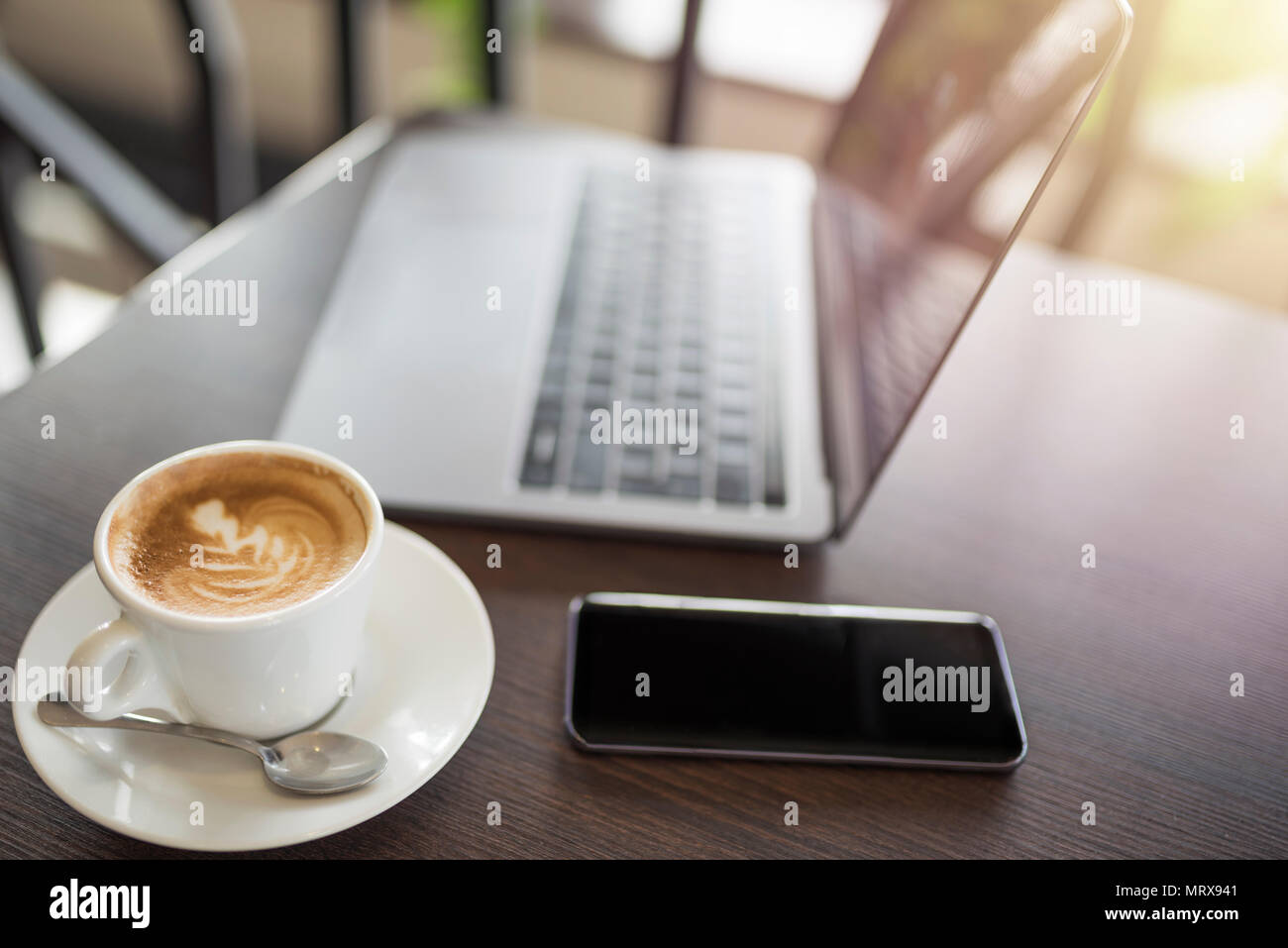 Coffee, smartphone and laptop on wooden table. Coffee break. Relax time ...