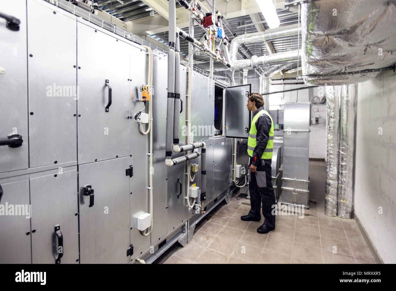Worker in electrical switchgear room of CNC plant Stock Photo - Alamy