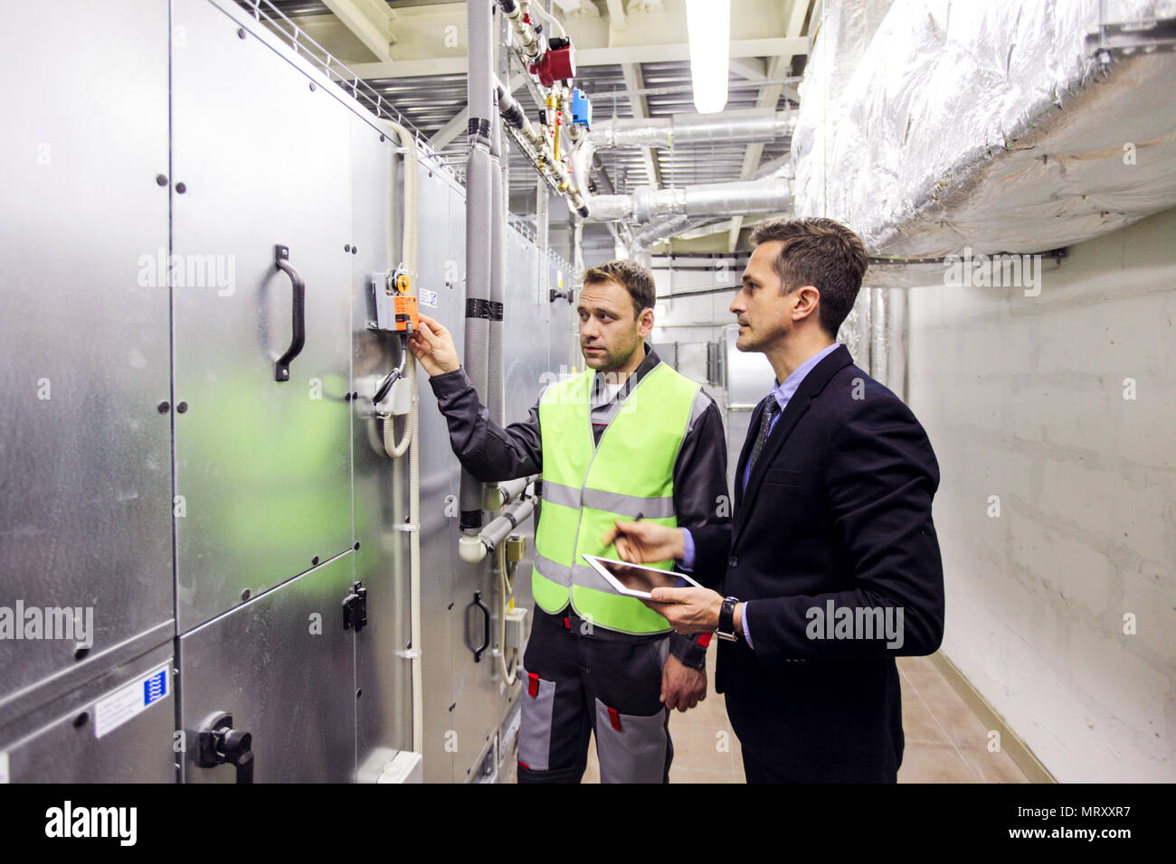 Worker and manager in electrical switchgear room of CNC plant Stock ...