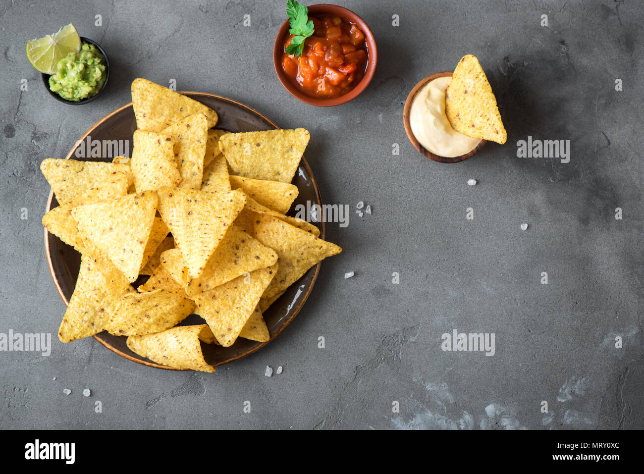 Nachos chips and various dip sauces. Tortilla corn nachos chips with ...