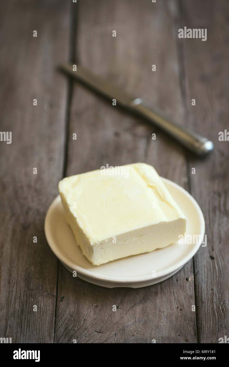 Butter on dark wooden background, copy space. Farm dairy product ...