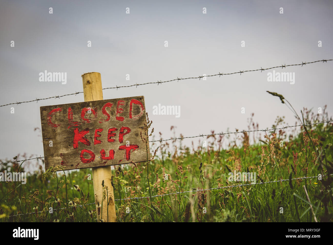 Hand made Keep out sign with barbed wire at field edge Stock Photo - Alamy
