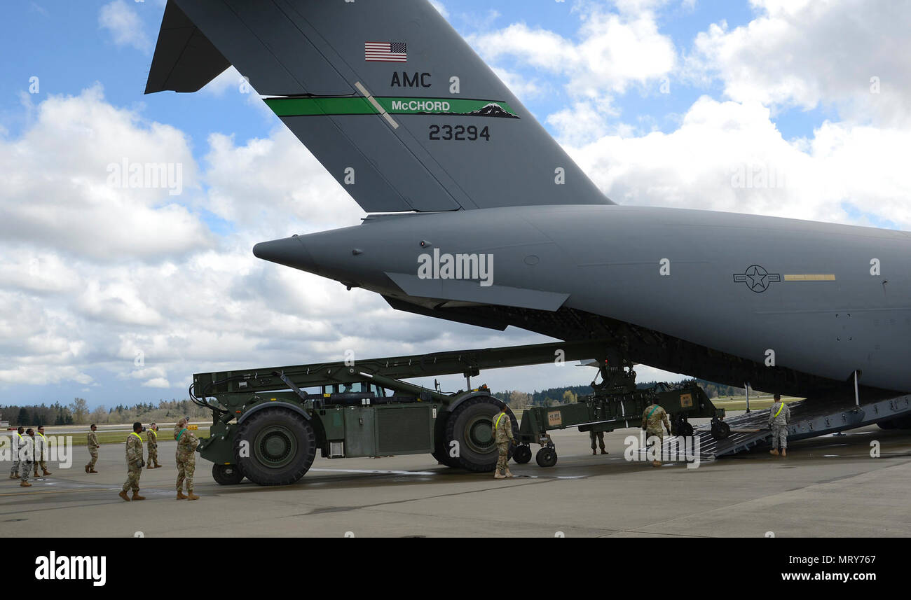 Airmen and Soldiers load a Rough Terrain Container Handler onto a C-17 ...