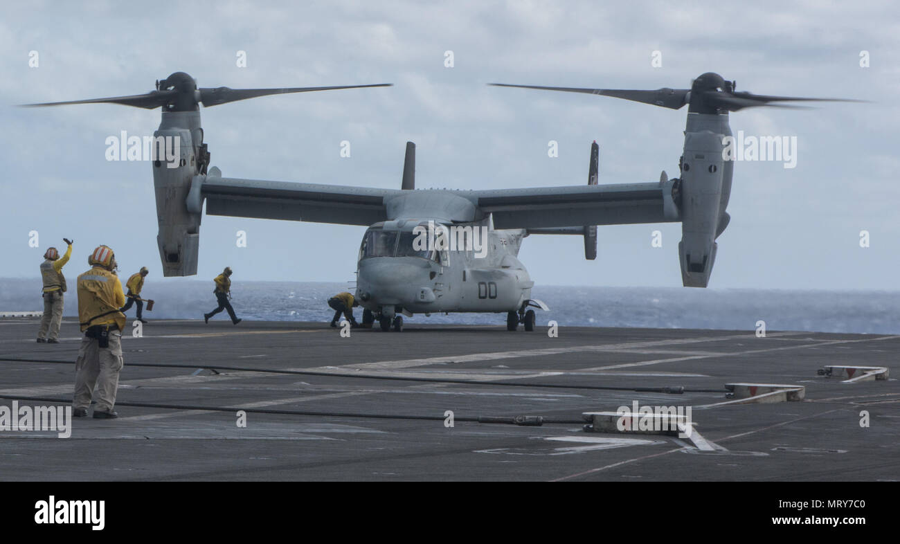 A Sailor moves to chalk and chain down an MV-22B Osprey, assigned to ...