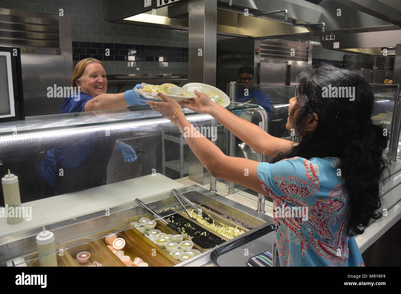 Debra Bratton hands Kartha Navya a plate during lunch in the Brooke ...