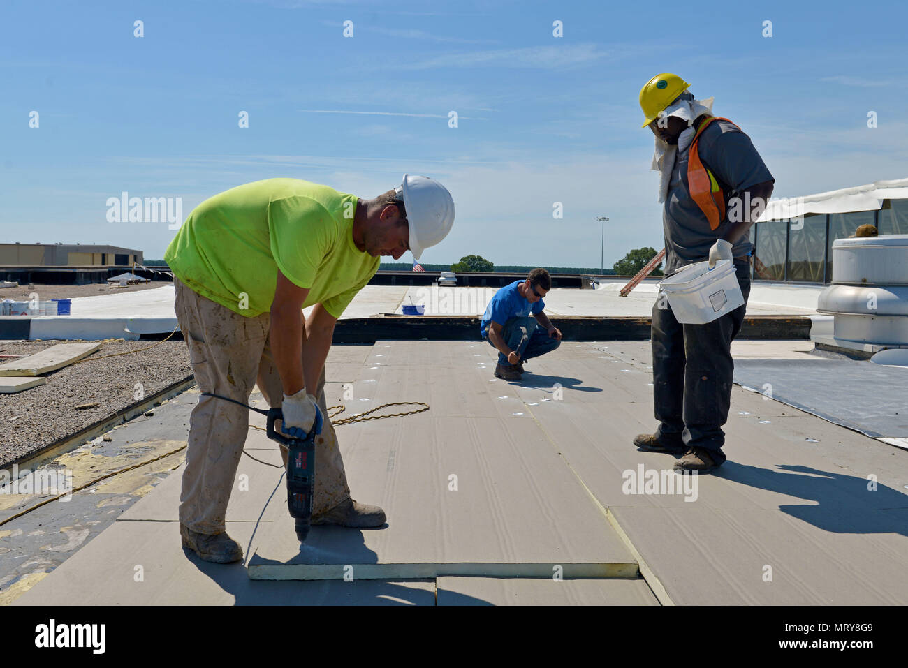 Kevin Doane, contractor, left, uses a hammer drill to create holes in ...