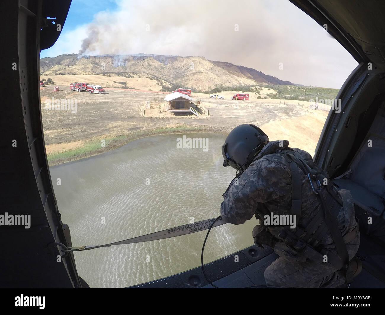 As a wildfire burns on a hill and California Department of Forestry and ...