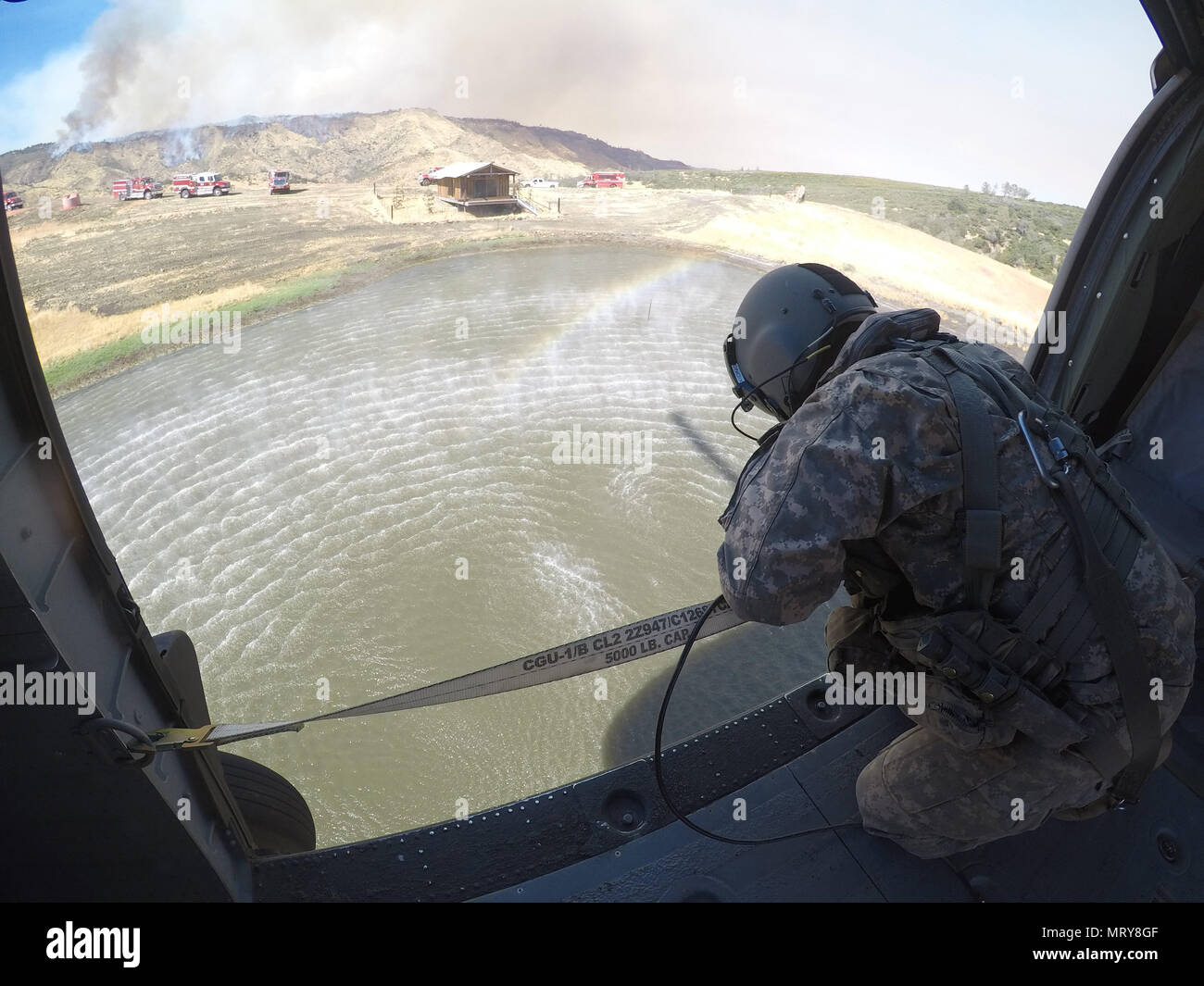 As a wildfire burns on a hill and California Department of Forestry and ...