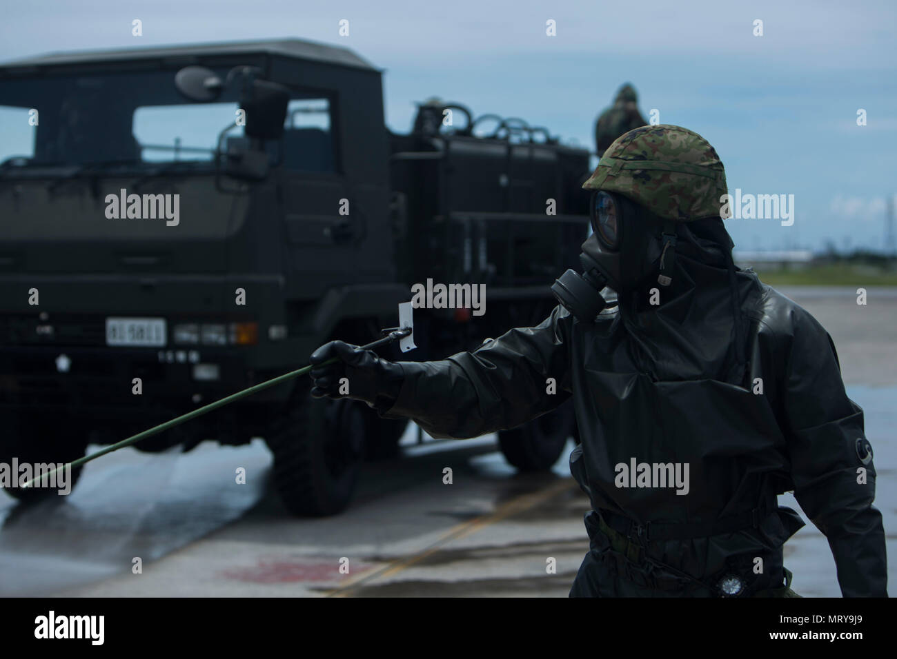A Japanese Ground Self-Defense service member directs a decontamination ...
