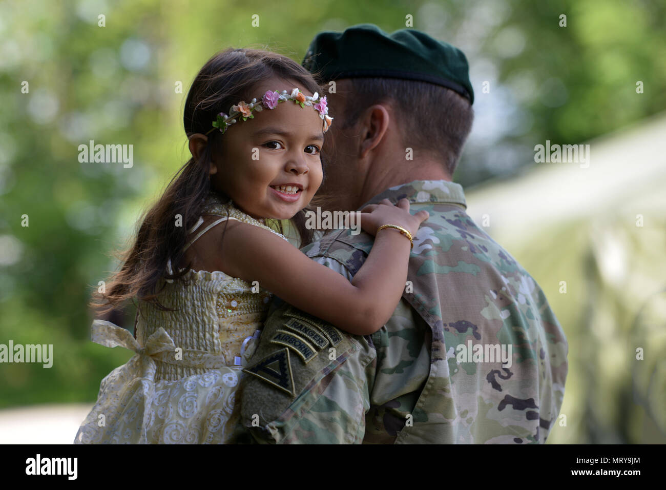 A U.S. Soldier carries his daughter up a long set of stairs before ...