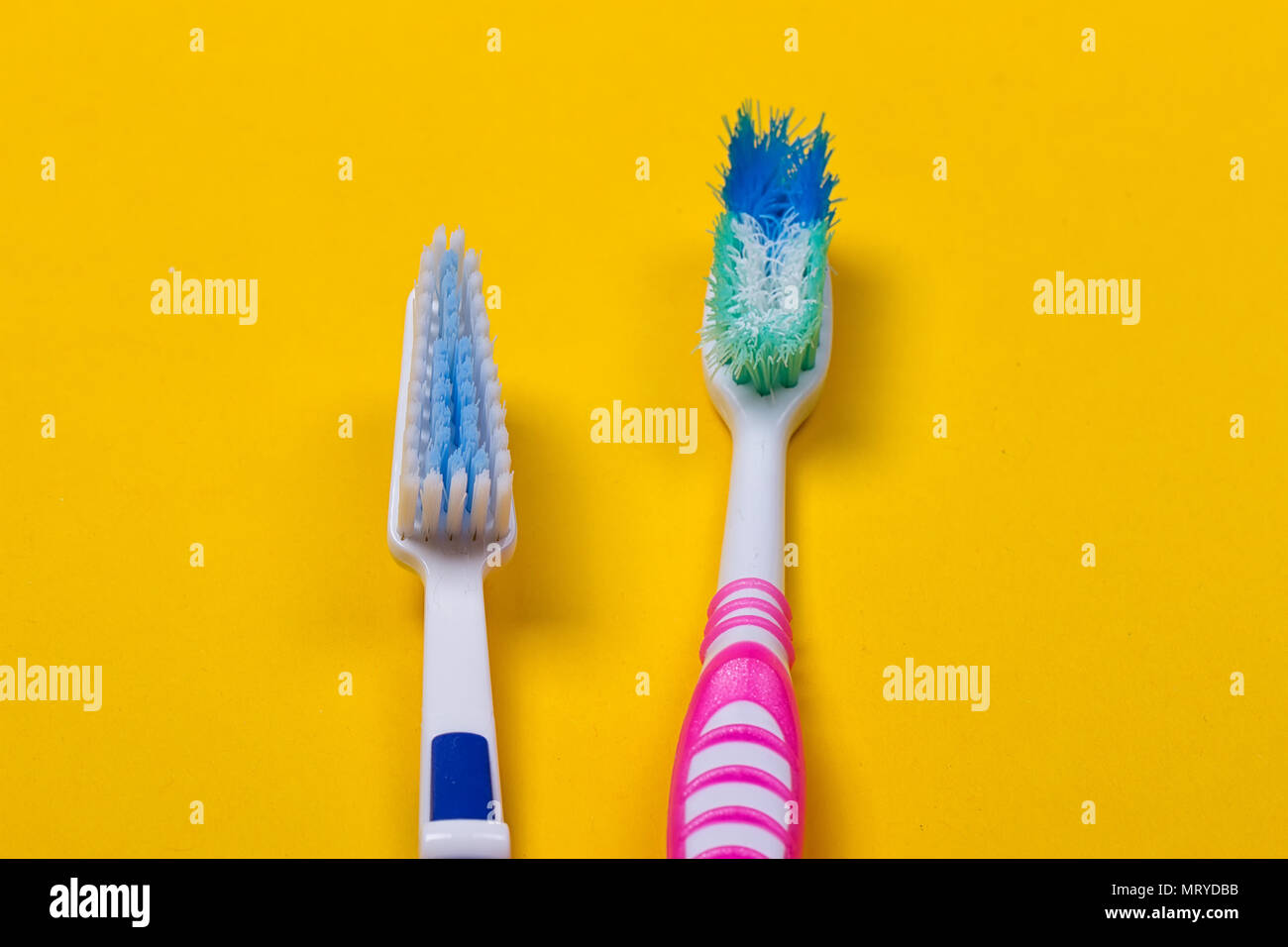 Old used and new toothbrushes on the yellow background. Top view Stock ...