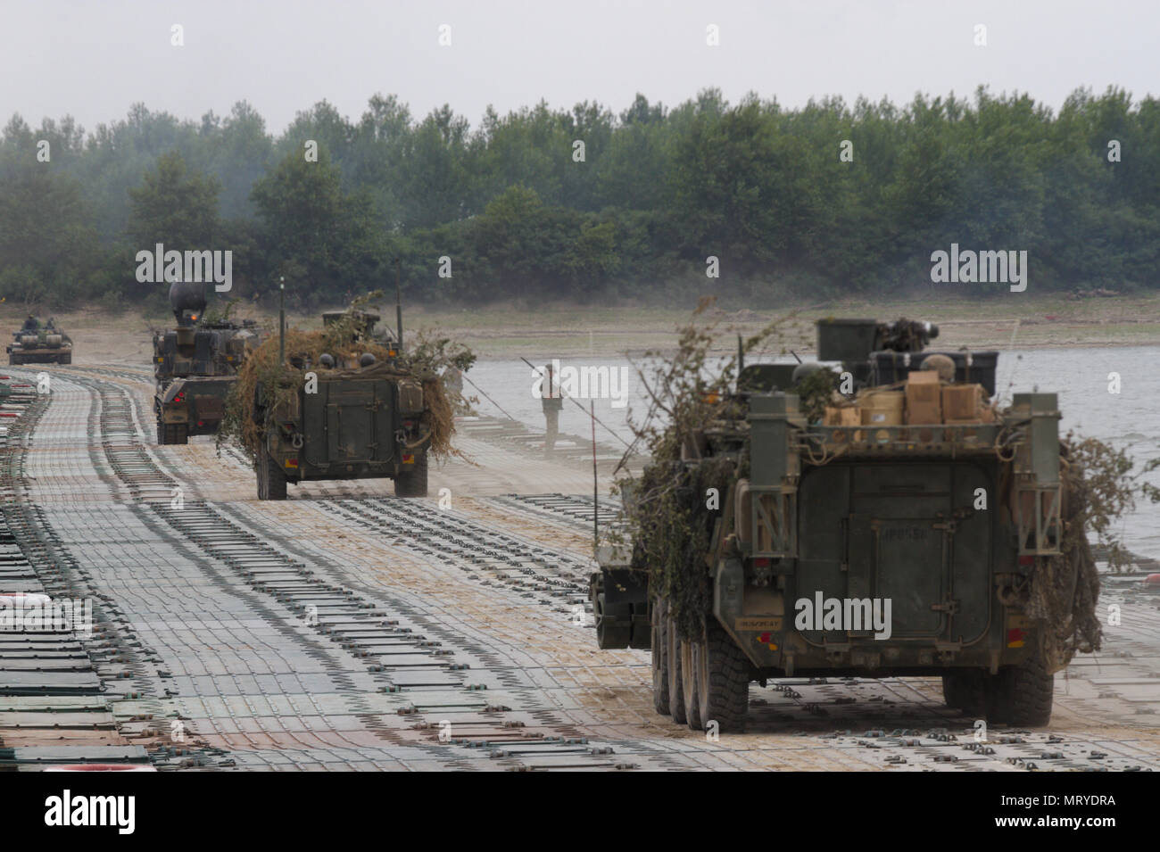 US Army M1126 Stryker Combat Vehicles drive across a recently completed ...