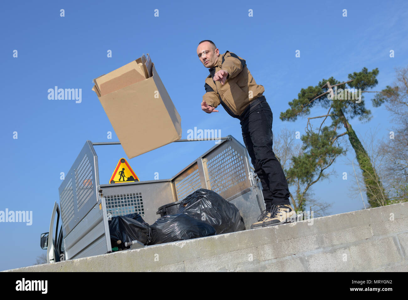 worker of municipal recycling garbage collector truck loading waste ...