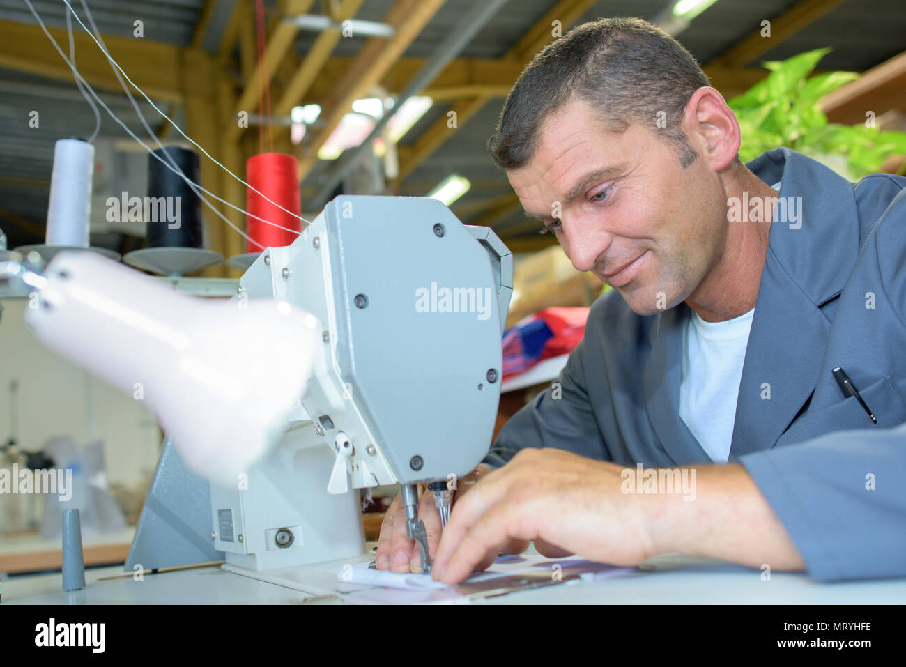 Man using sewing machine Stock Photo - Alamy