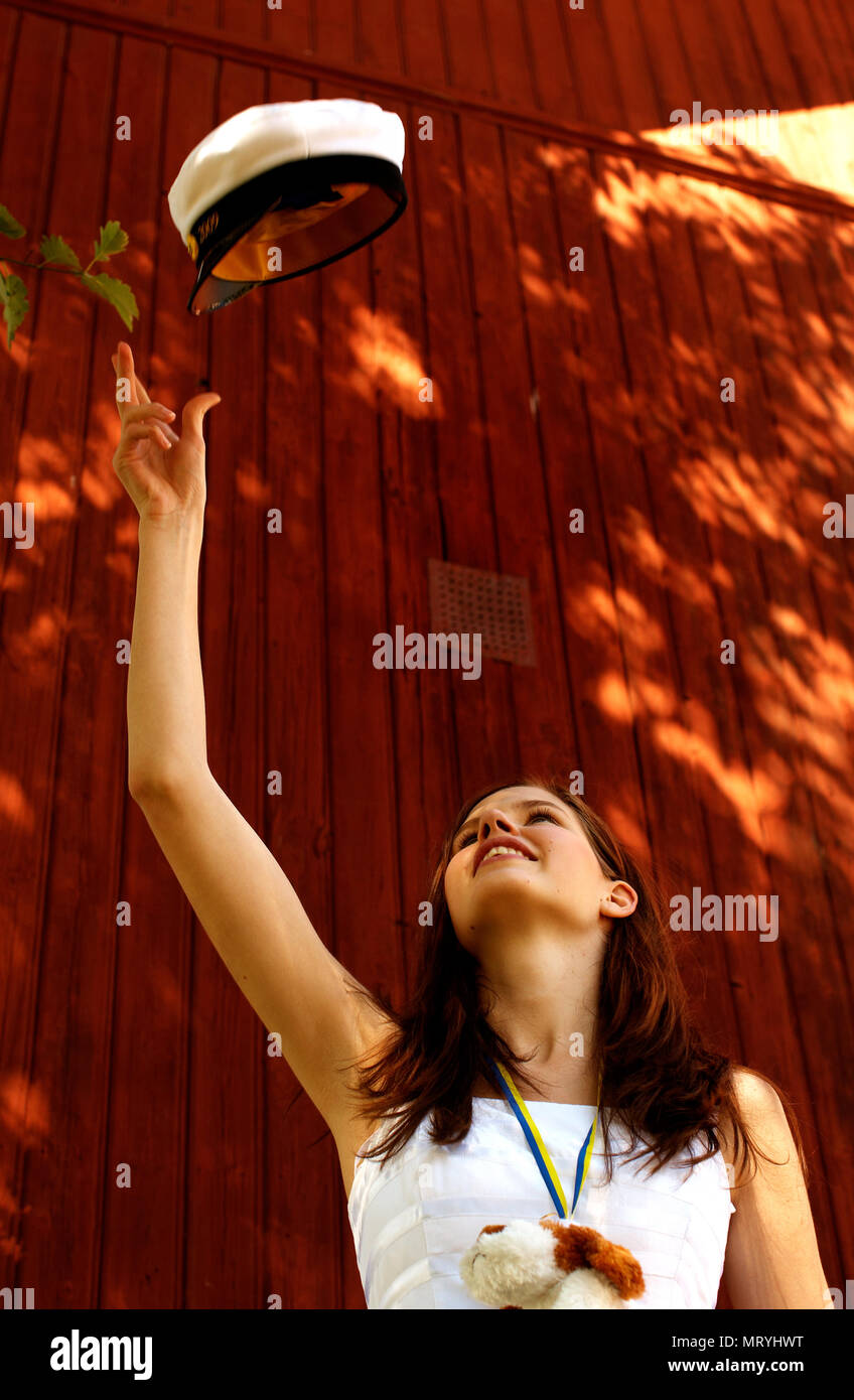 Swedish female student with traditional gradiuation cap throws the cap ...