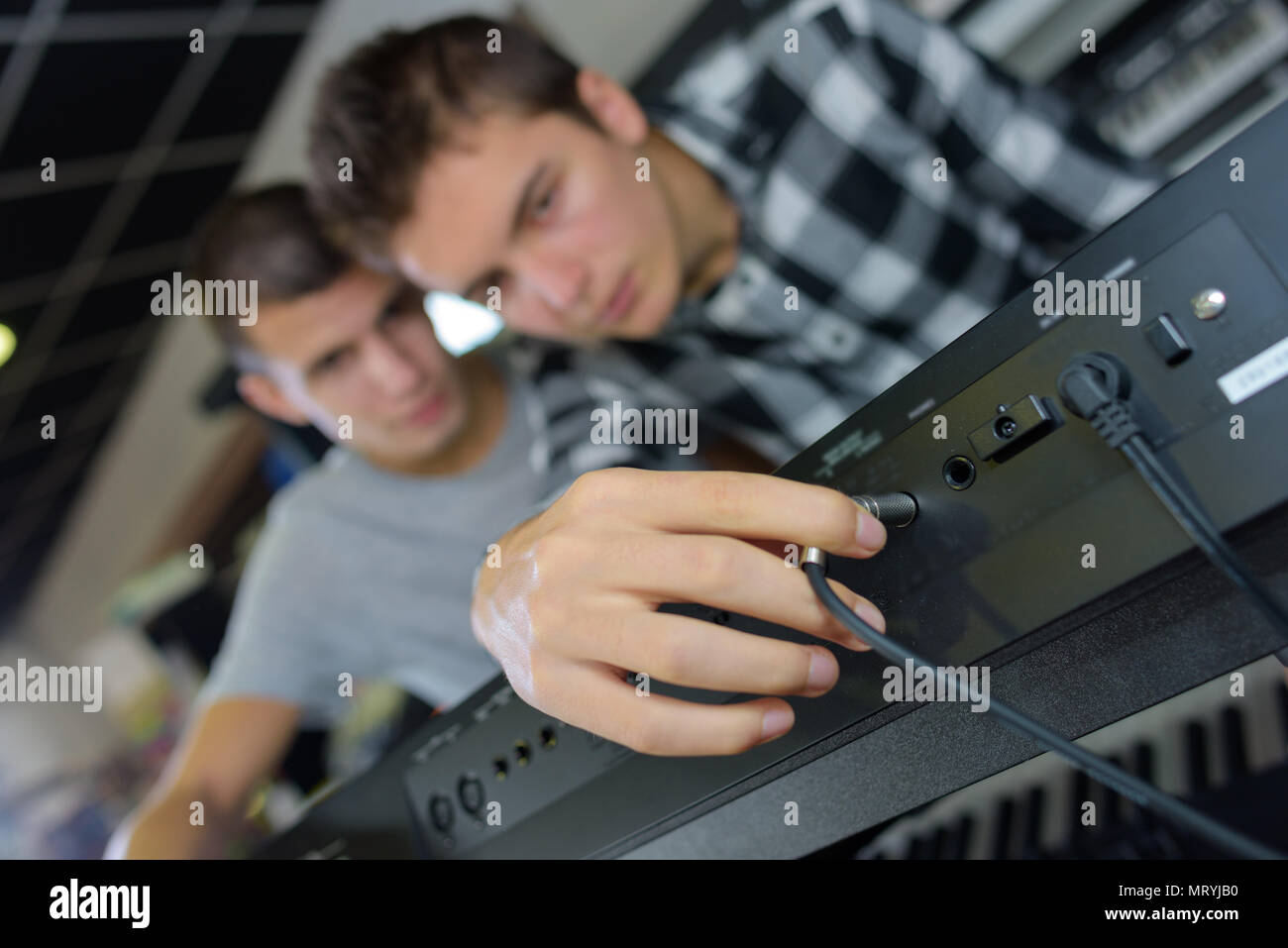 Young man plugging in electrical lead Stock Photo - Alamy