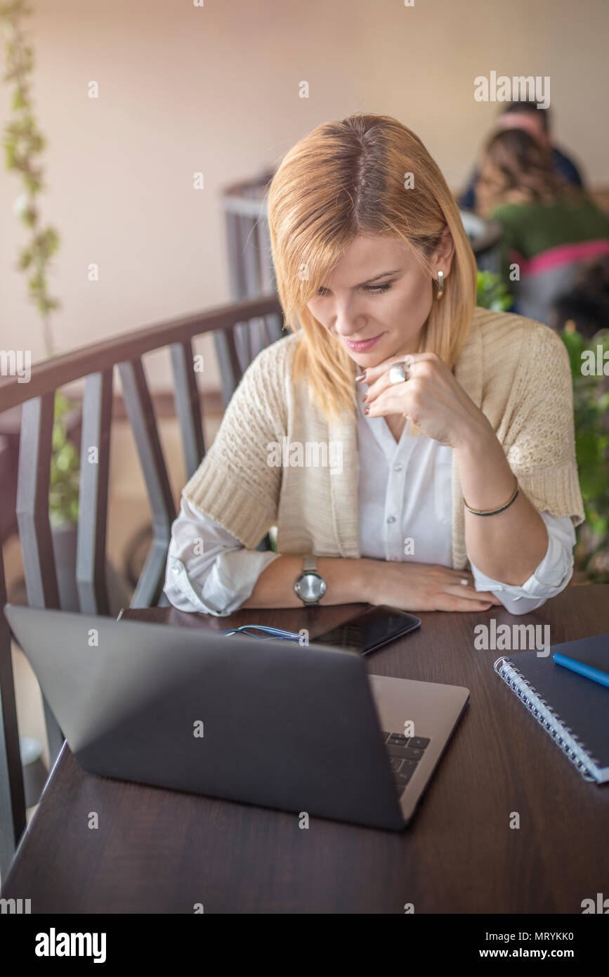 Young business woman using her laptop computer to solve business ...