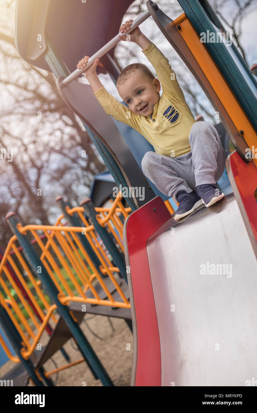 Adorable little boy having fun on playground. Active sport leisure for ...