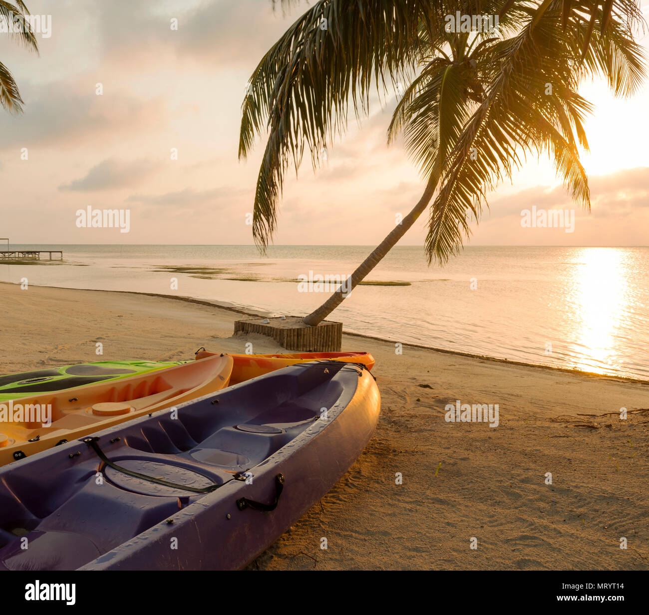 Kayaks sitting on the beach at dawn with a beautiful sunrise Stock ...
