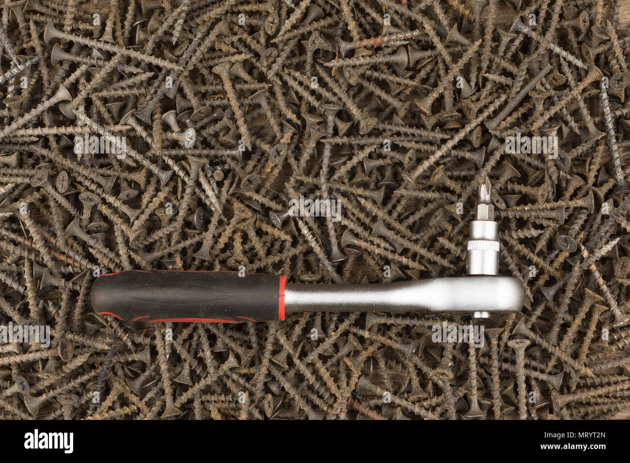 Screwdriver lying on a pile of screws. View from above Stock Photo - Alamy