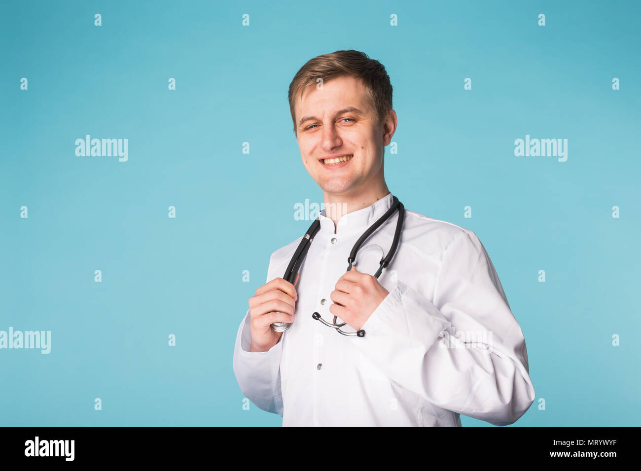 Portrait of handsome male doctor over blue background Stock Photo - Alamy