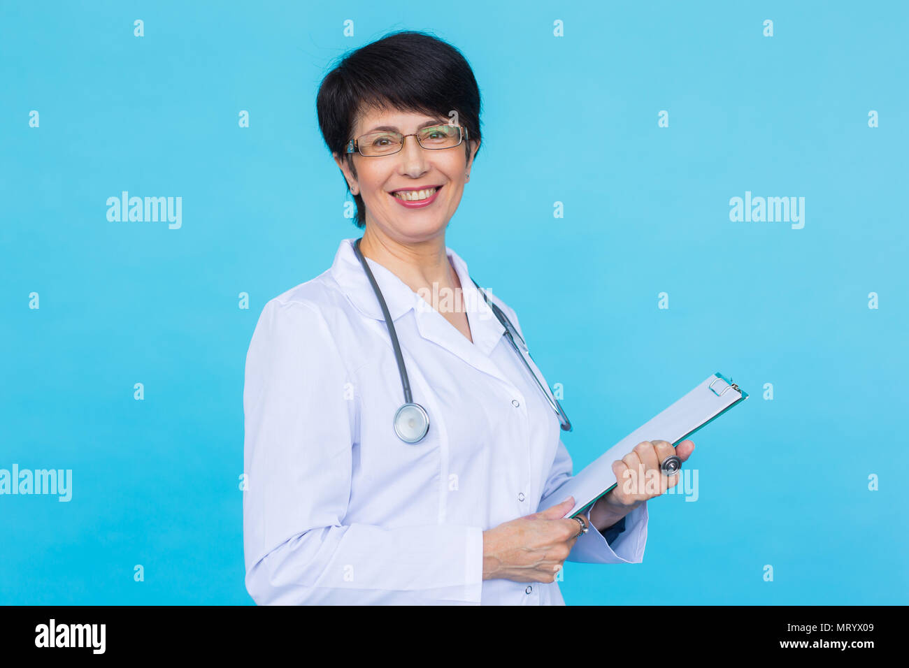 Medical doctor writing prescription over blue background Stock Photo ...