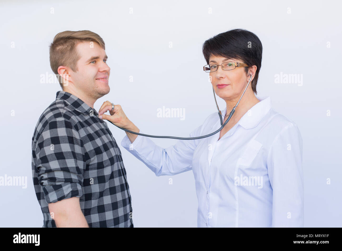 Portrait of confident doctor checking heartbeat of patient Stock Photo ...