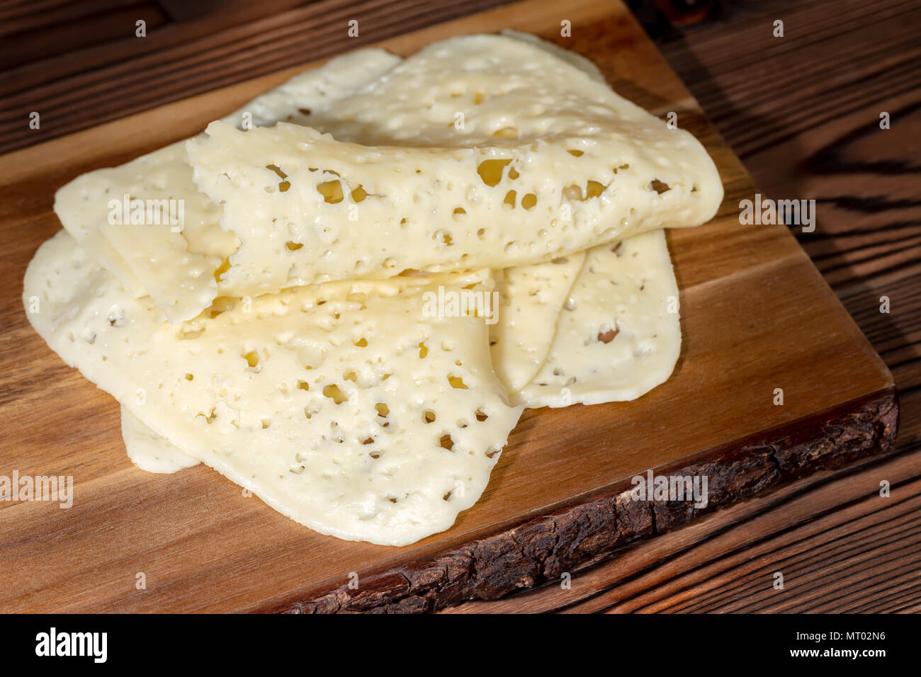 lace cheese sliced on wooden cutting board Stock Photo - Alamy