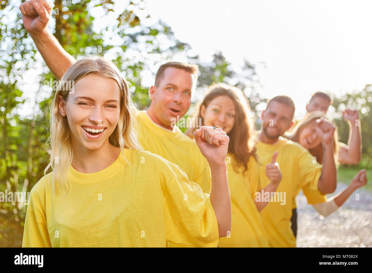 Young woman cheers together with her team at the team building workshop ...