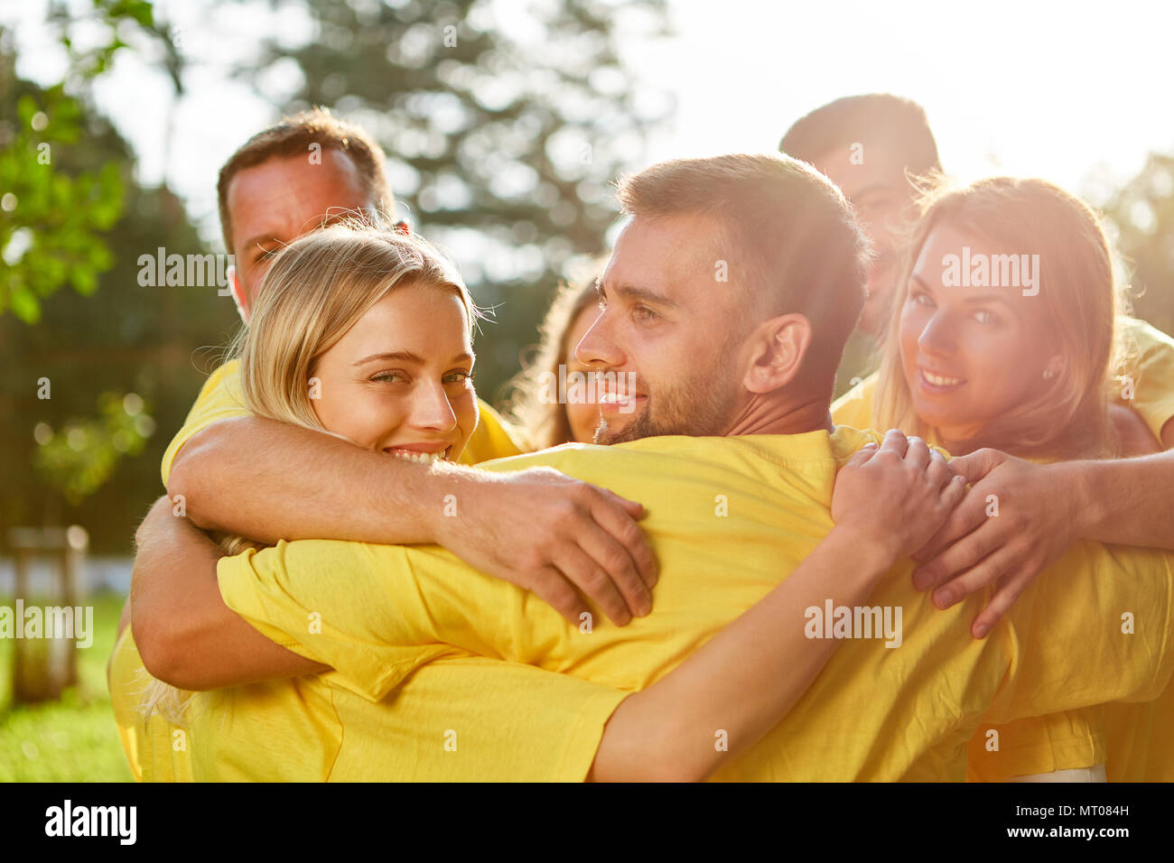Successful young team hugs each other happily at the teambuilding ...