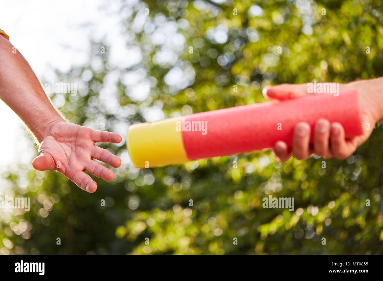 A baton is handed over during a relay race in the team building ...