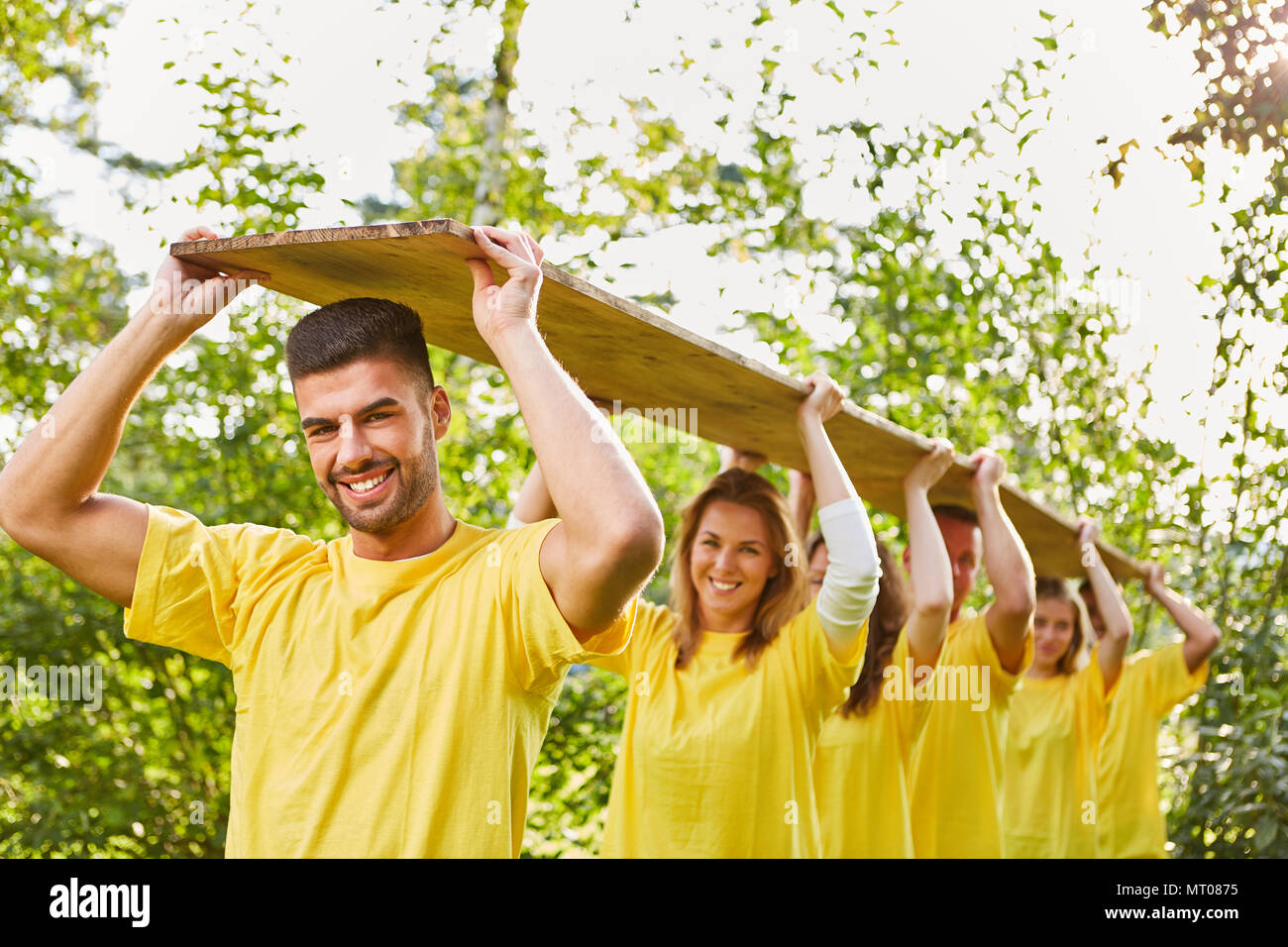 Young people in the team together wear a wooden board at a team ...