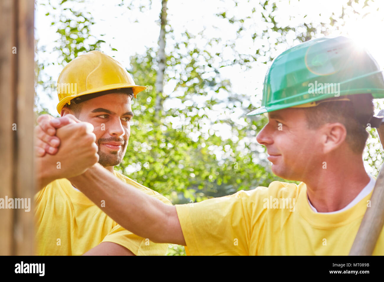 Two men as construction workers in house construction look forward to ...