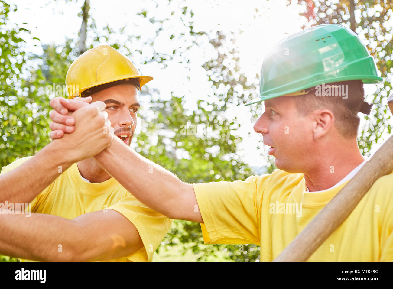 Two construction workers congratulate each other on the successful ...