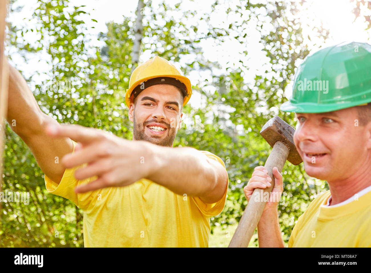 Two construction workers are working in teamwork on a construction site ...
