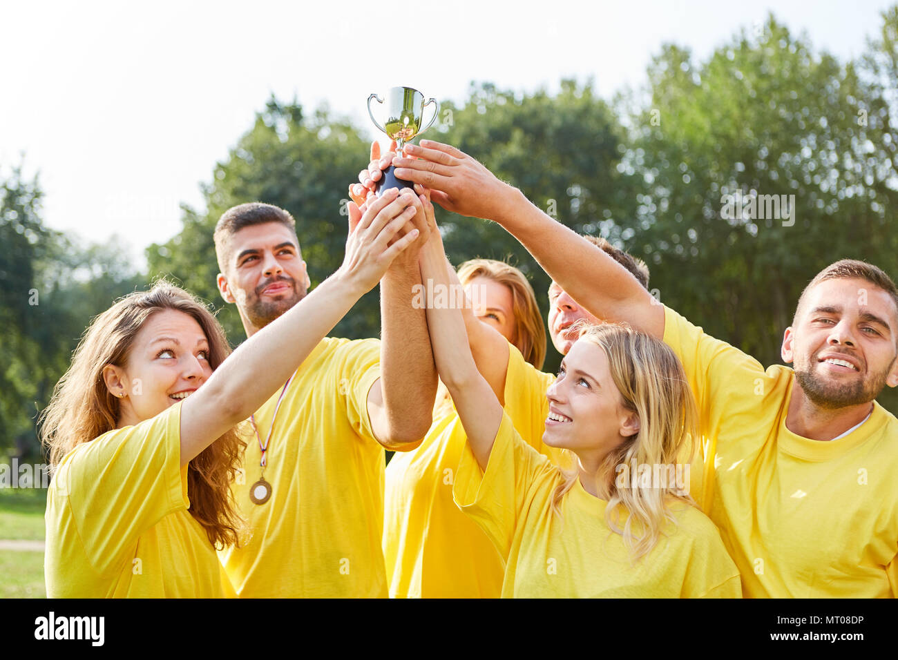 Successful young winner team proudly holds the trophy high at the ...