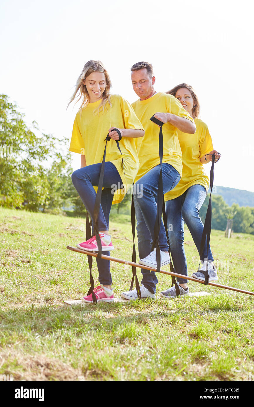 Three young people do an exercise with the elastic band for team ...
