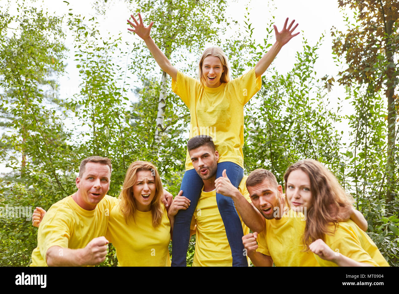 Successful team cheers with wife in piggy back at a teambuilding event ...