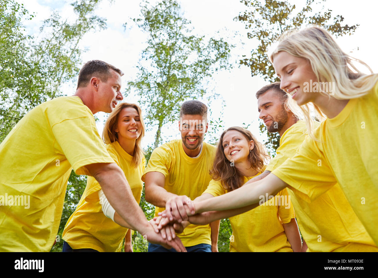 Young people in start-up team stack hands in a teambuilding exercise ...