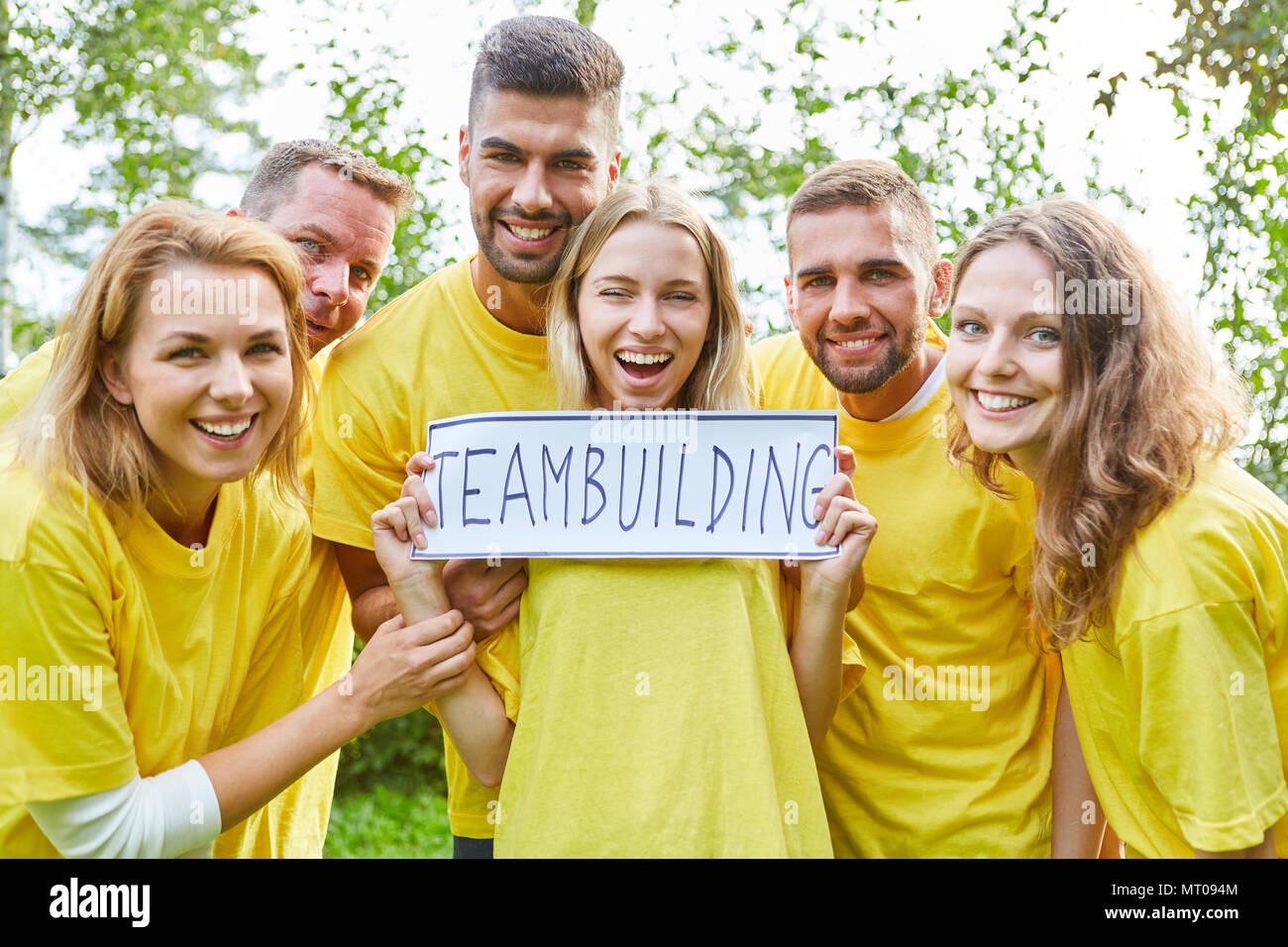 Young start-up team with a teambuilding sign in a business workshop ...
