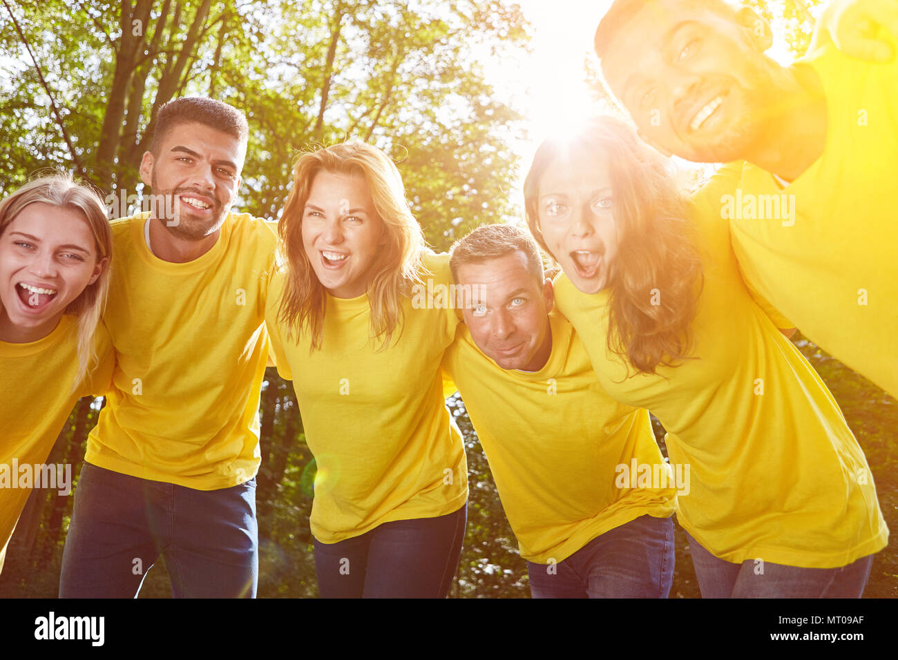 Laughing group as a team in hug to motivation in nature Stock Photo - Alamy