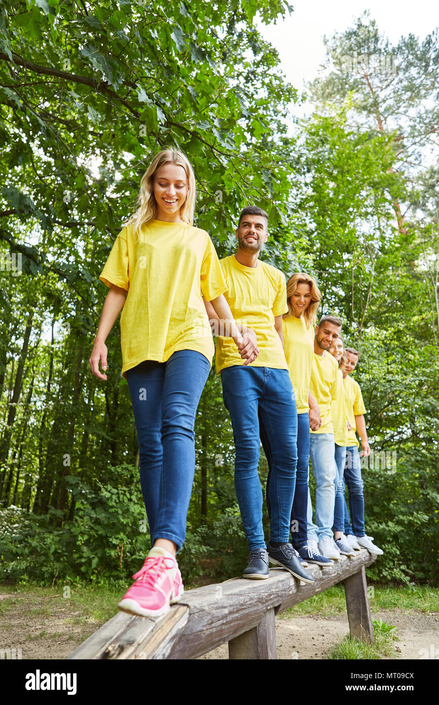 Young people as a team on the balance beam at a team building event ...