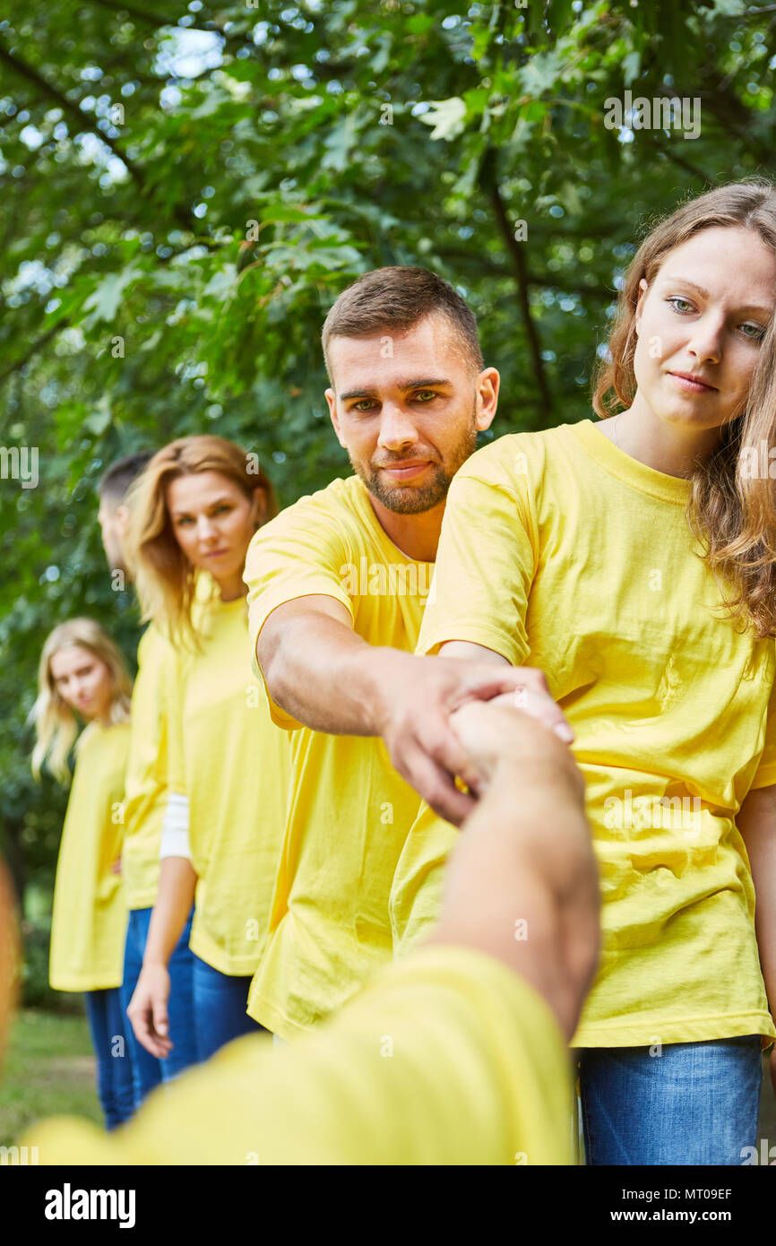 Young people help themselves in a teamwork team development exercise ...